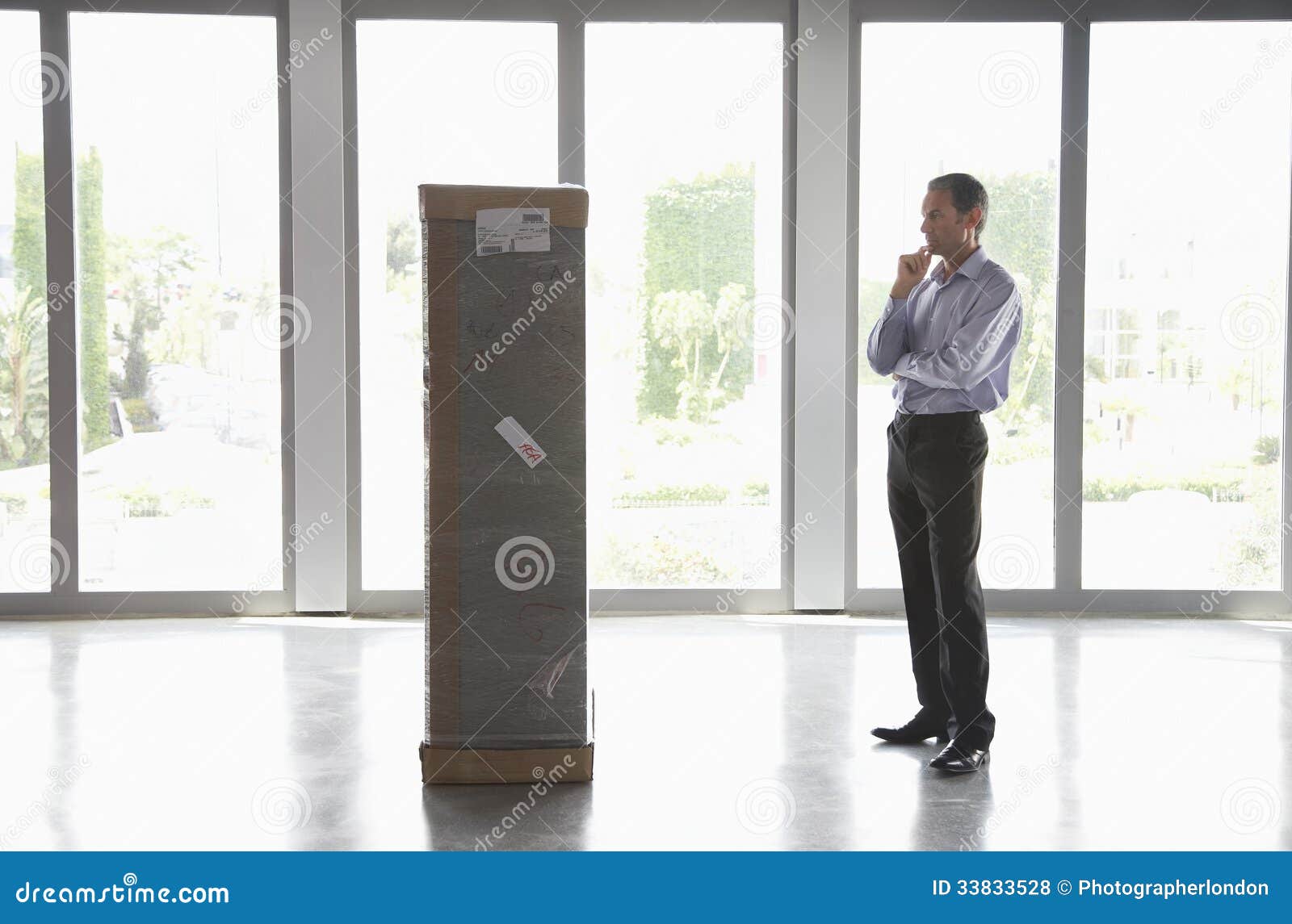 Man Observing Package in Empty Office Stock Photo - Image of loneliness ...