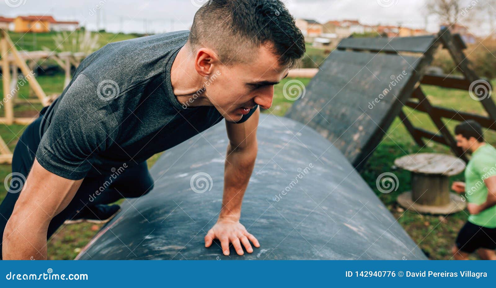 Man in an Obstacle Course Climbing a Drum Stock Photo - Image of ...