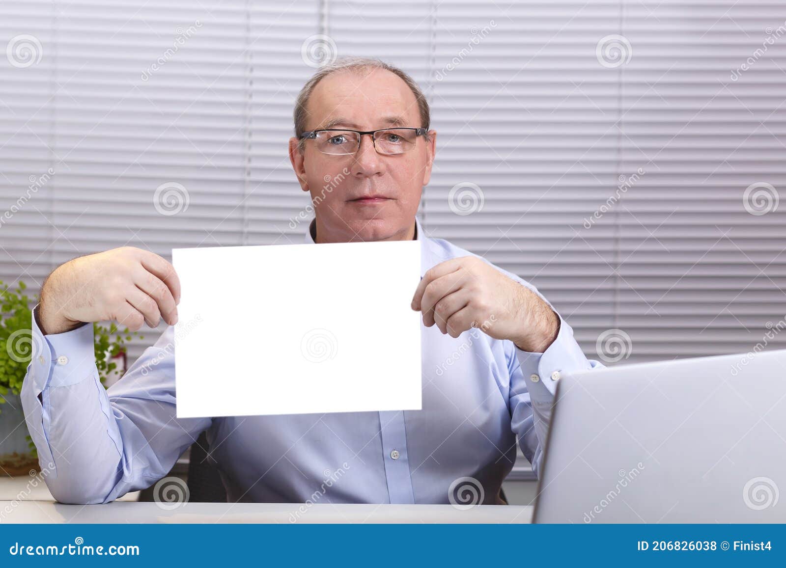 A Man in the Office at the Computer Holds a Sign in His Hands Stock ...