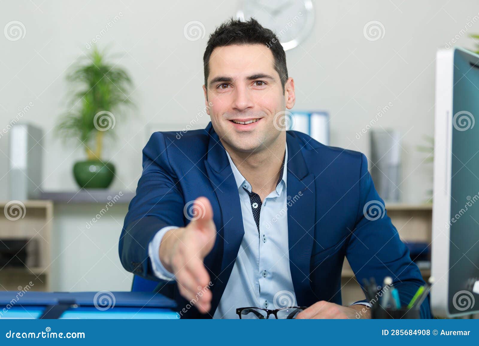 Man at Office Desk Proffering Hand To Shake Stock Photo - Image of ...