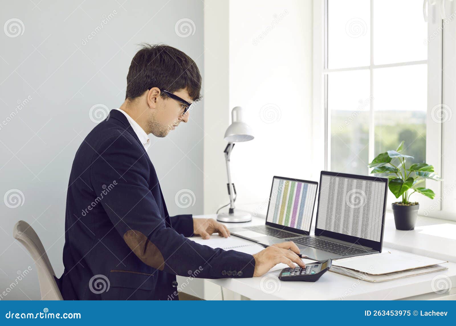 Man Office Worker is Working with Spreadsheets on Computers Screens and ...