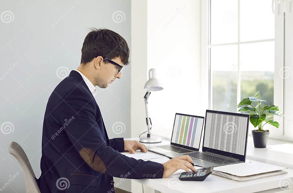 Man Office Worker is Working with Spreadsheets on Computers Screens and ...