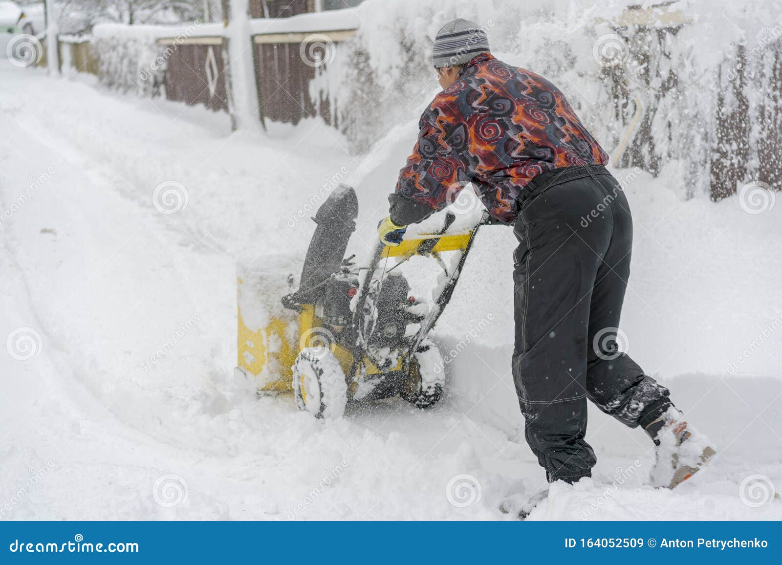 Man Operating Snow Blower To Remove Snow on Driveway. Man Using a ...