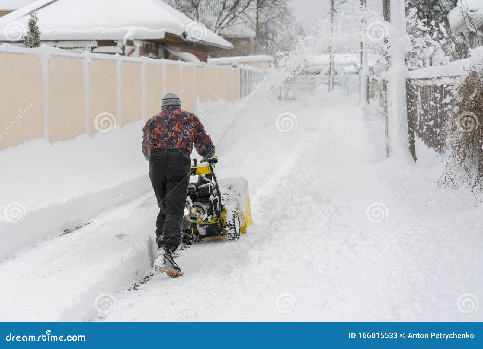 Man Operating Snow Blower To Remove Snow On Driveway. Man Using A ...