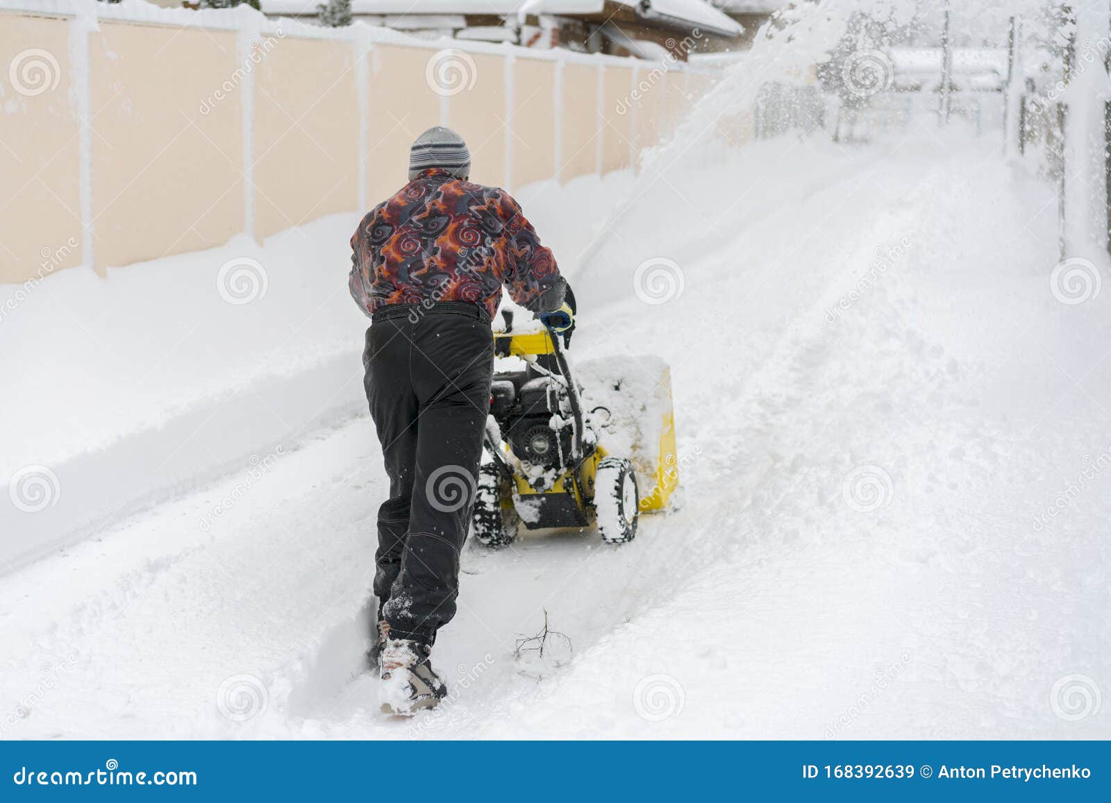 Man Operating Snow Blower To Remove Snow on Driveway. Man Using a ...