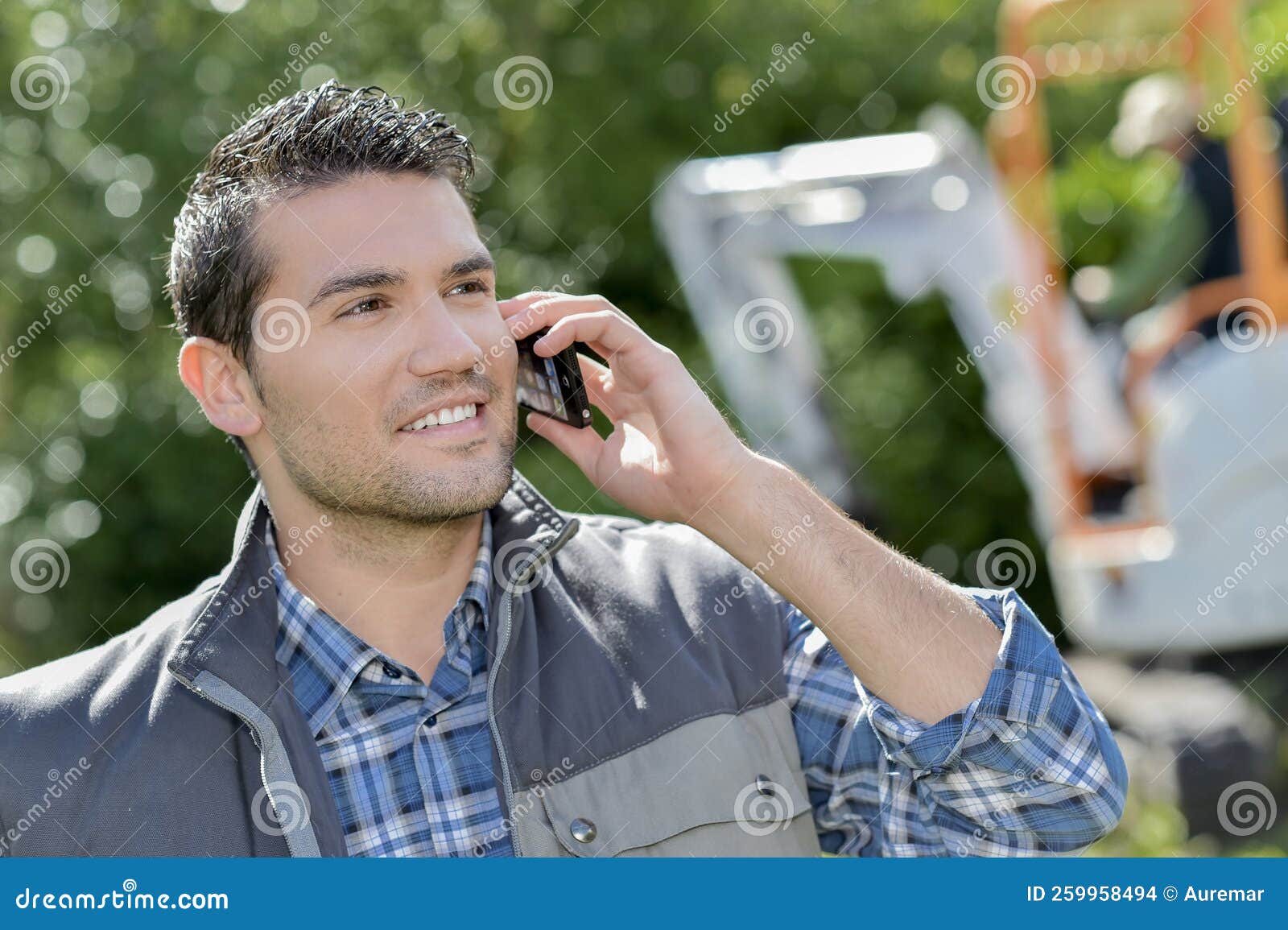 Man Outdoors on Telephone Digger in Background Stock Photo - Image of ...