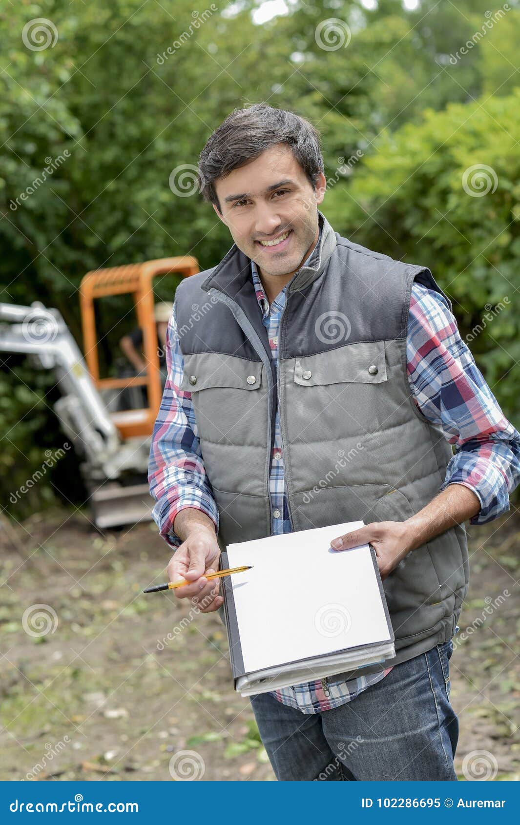 Man Outside in Front Digger Holding Paper and Folder Stock Image ...