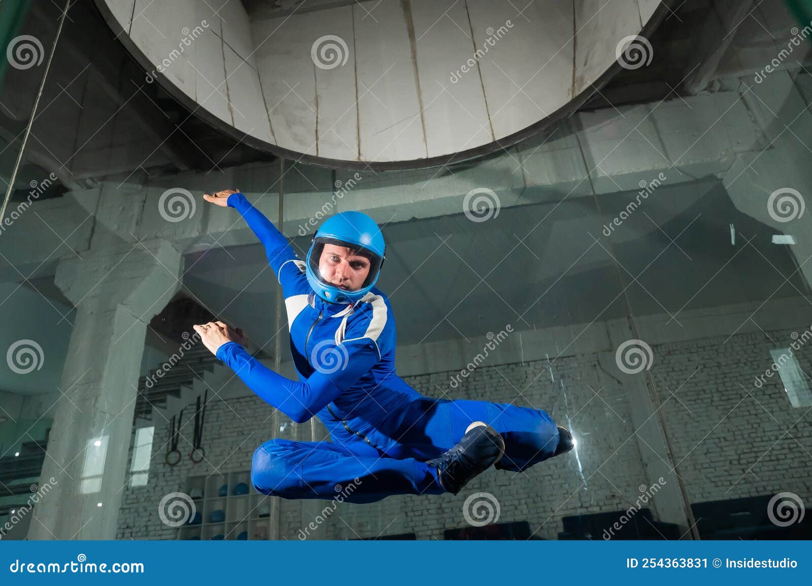 A Man in Overalls and a Protective Helmet Enjoys Flying in a Wind ...