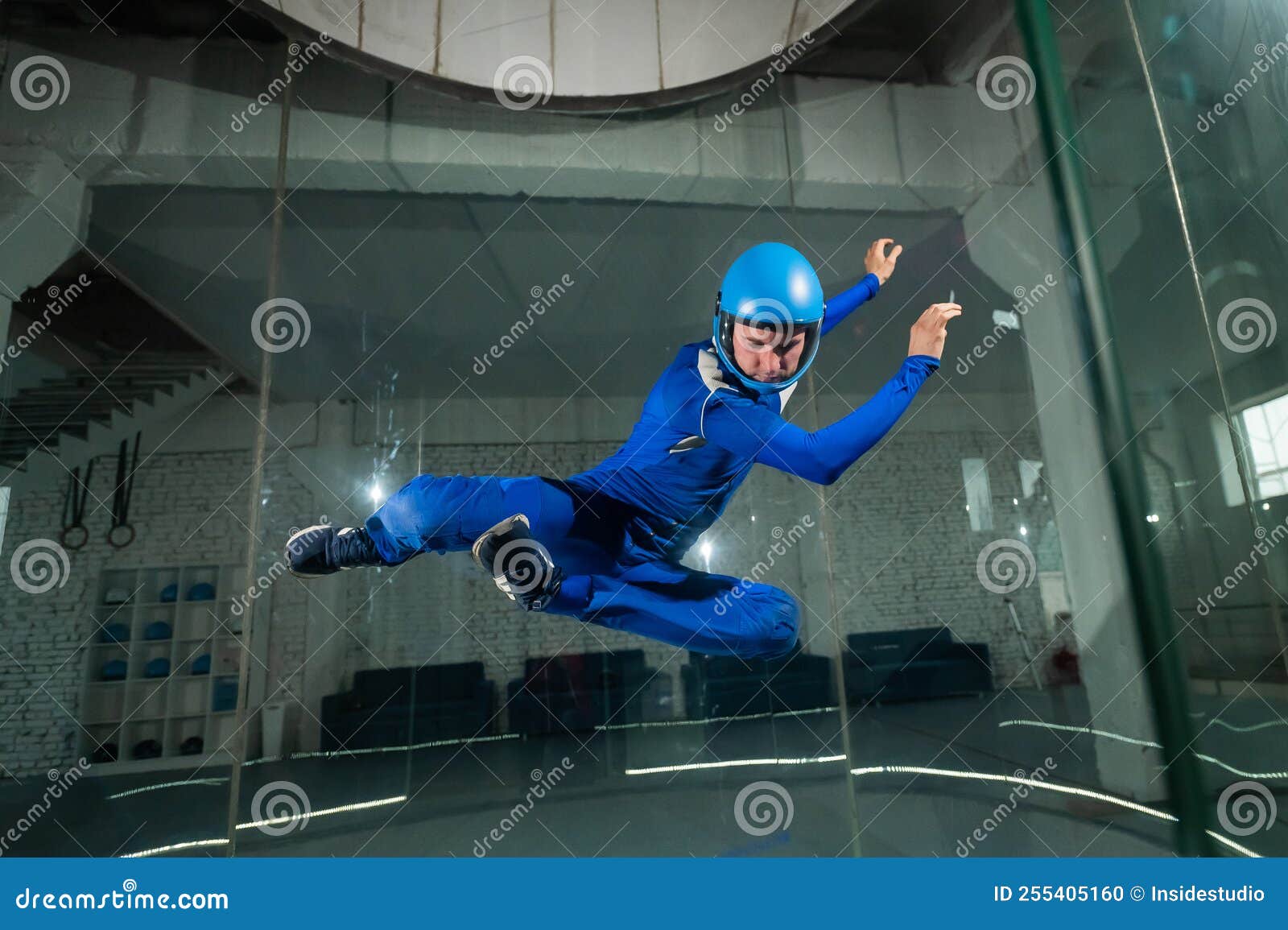 A Man in Overalls and a Protective Helmet Enjoys Flying in a Wind ...