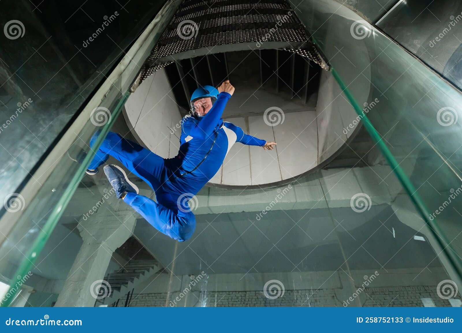 A Man in Overalls and a Protective Helmet Enjoys Flying in a Wind ...