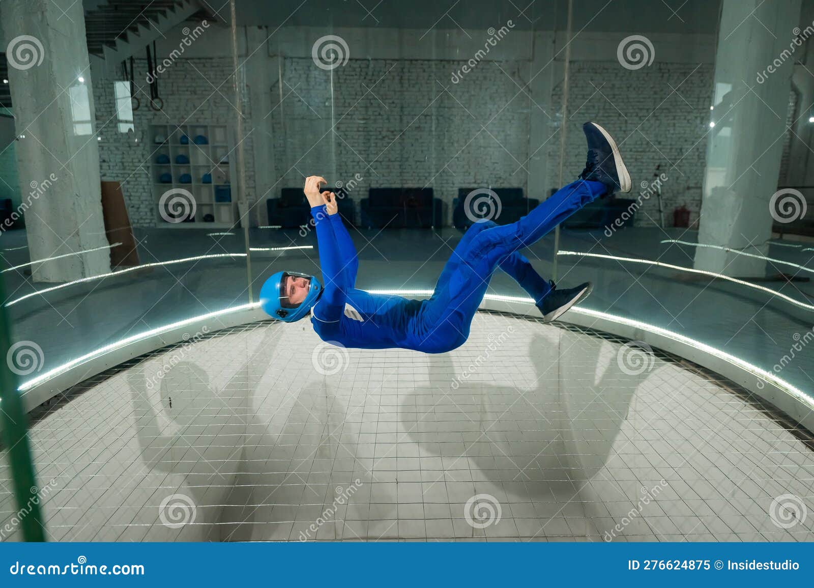 A Man in Overalls and a Protective Helmet Enjoys Flying in a Wind ...