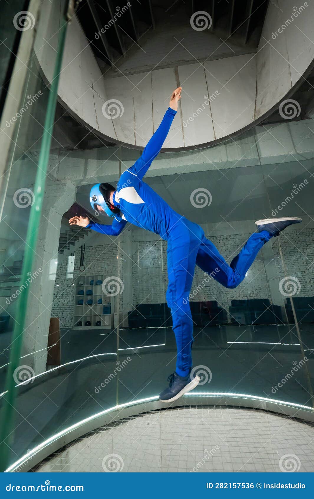 A Man in Overalls and a Protective Helmet Enjoys Flying in a Wind ...