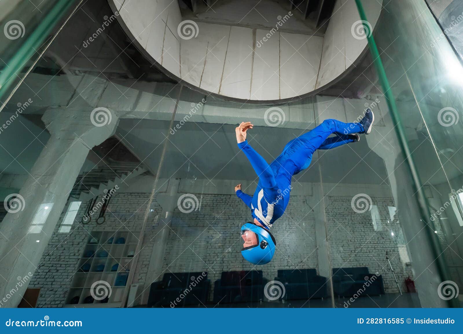 A Man in Overalls and a Protective Helmet Enjoys Flying in a Wind ...