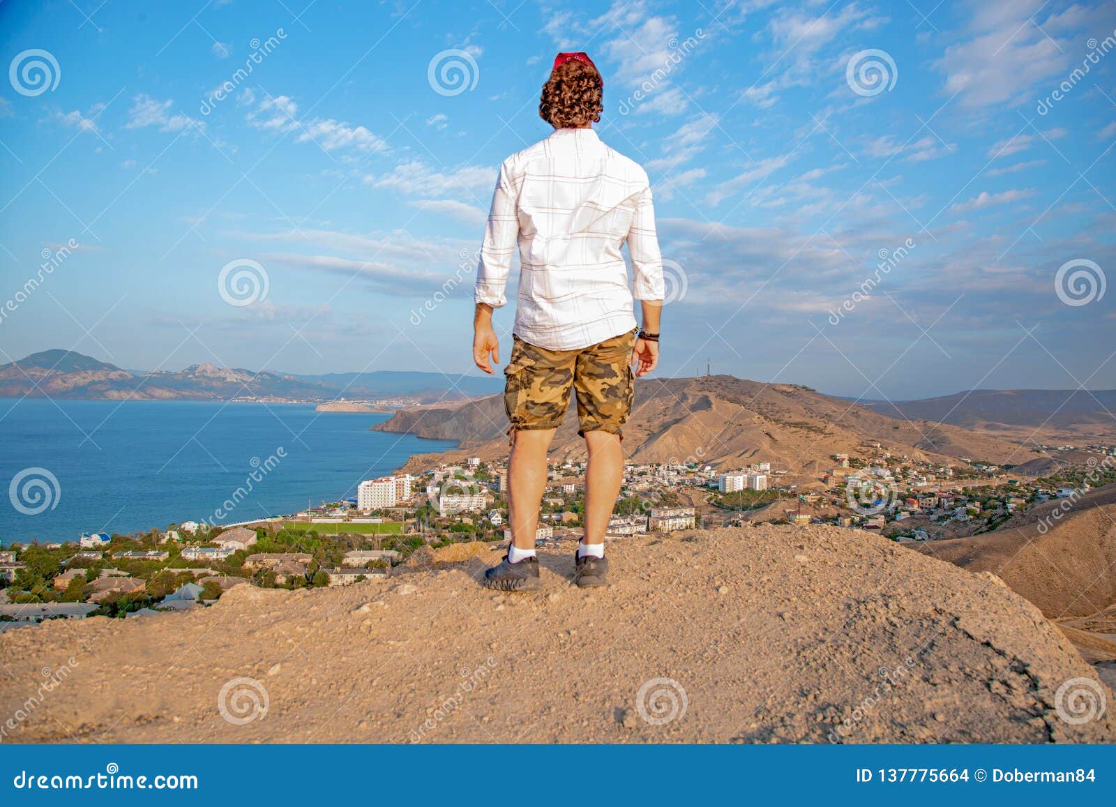 A Man Overlooking a Panoramic View of a Beautiful Coastline from the ...