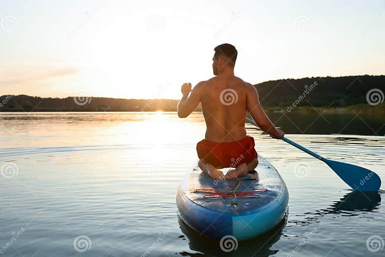 Man Paddle Boarding on SUP Board in River at Sunset, Back View Stock ...
