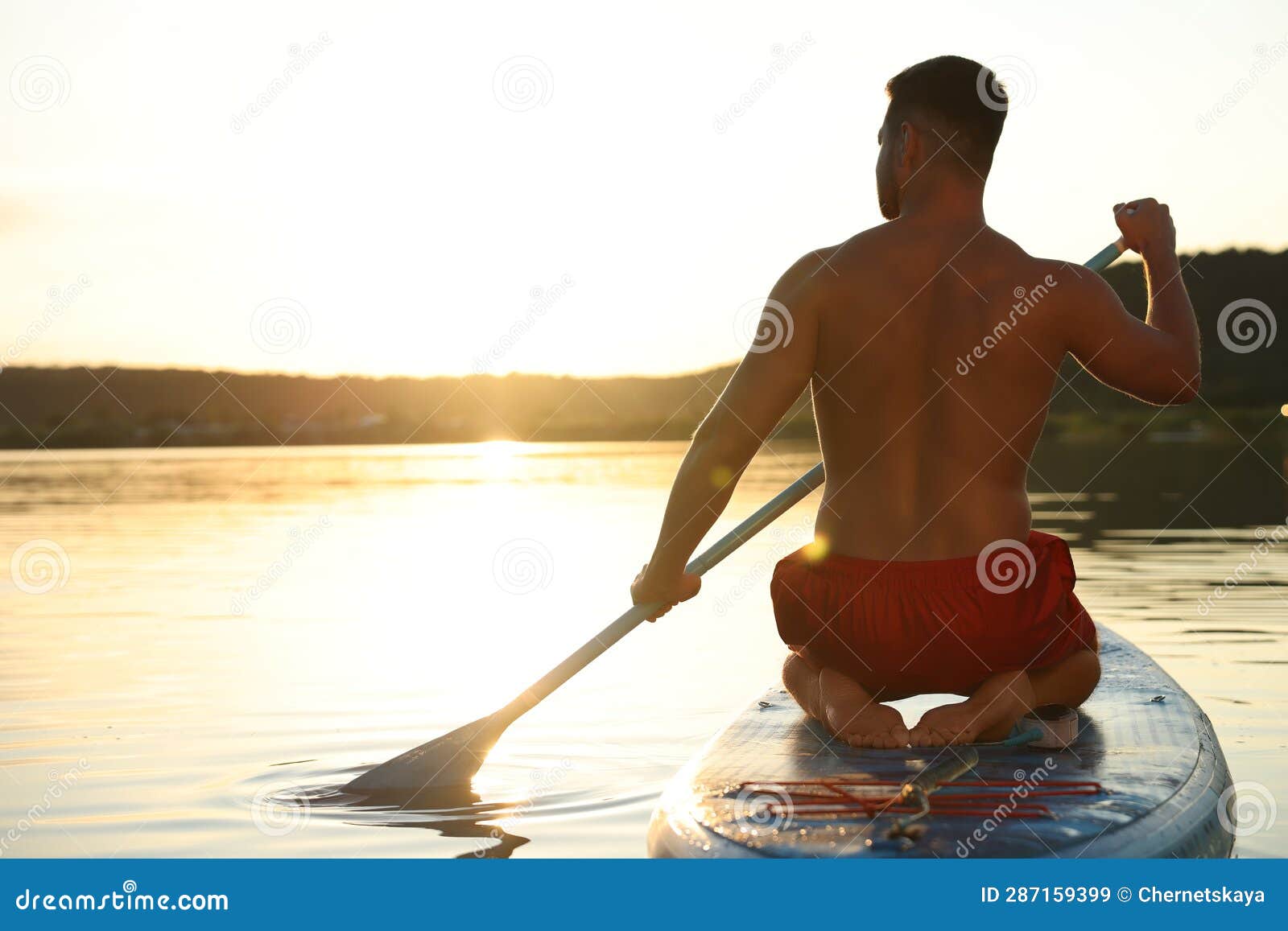 Man Paddle Boarding on SUP Board in River at Sunset, Back View Stock ...