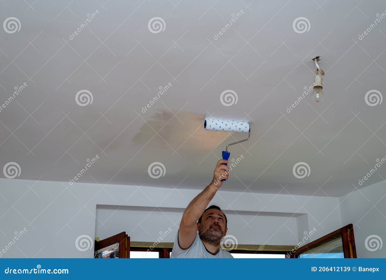 Man painting a ceiling stock image. Image of apartment - 206412139