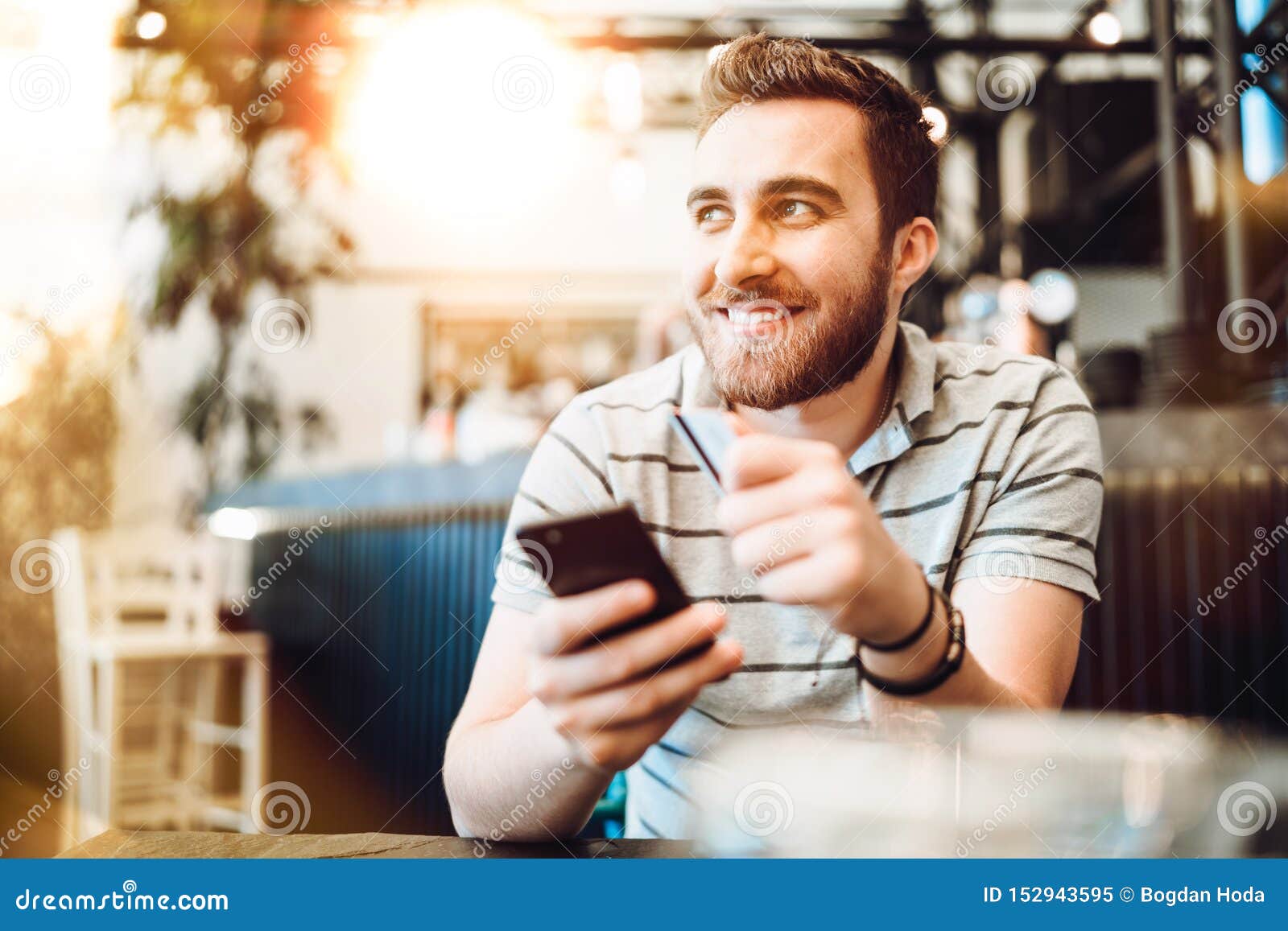 Man Paying Using Credit Card and Mobile Phone. Modern Payment Systems ... Man Paying Using Credit Card and Mobile Phone. Modern Payment Systems ...