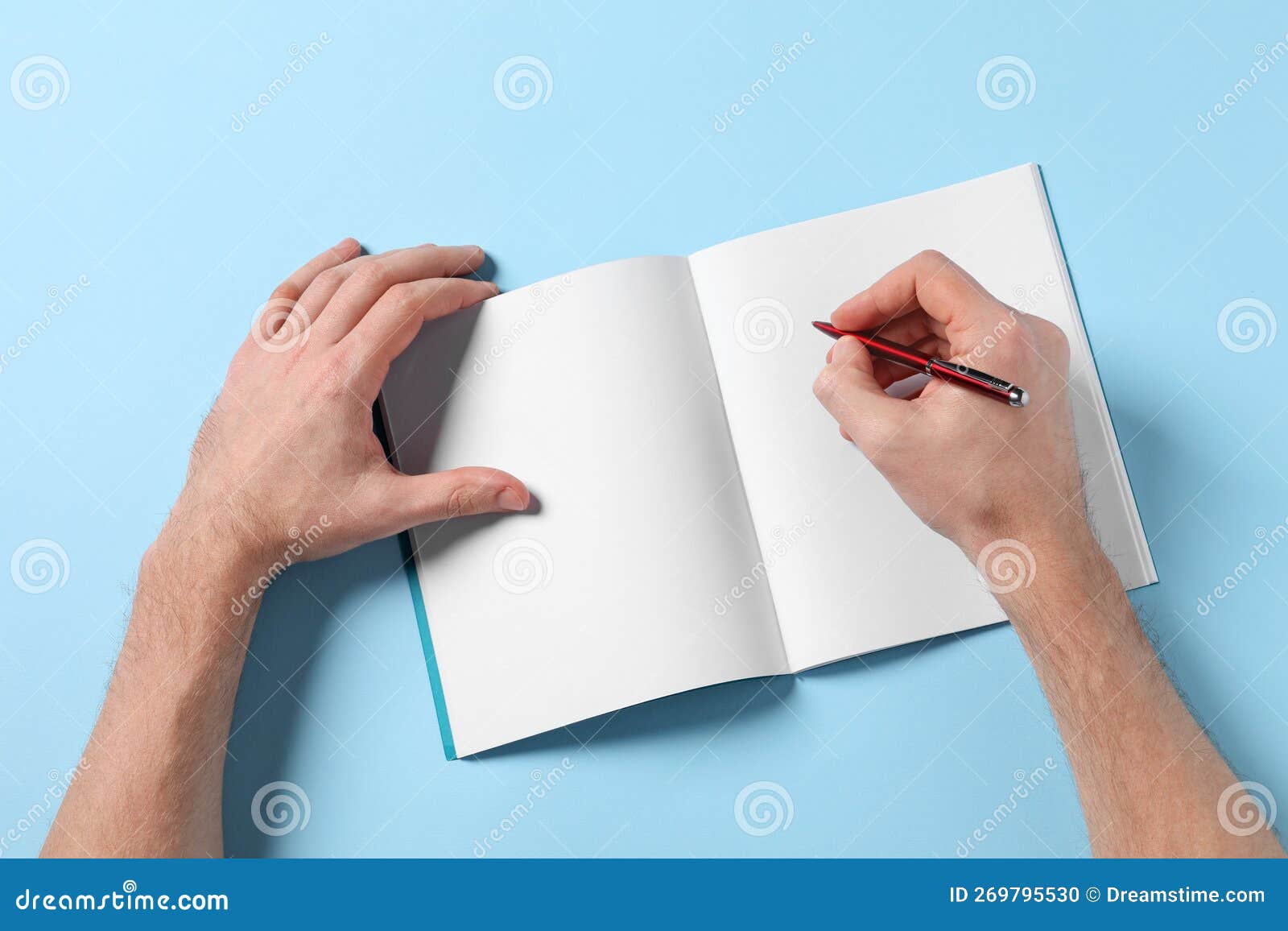 Man with Pen and Empty Notepad on Light Blue Background, Top View Stock ...