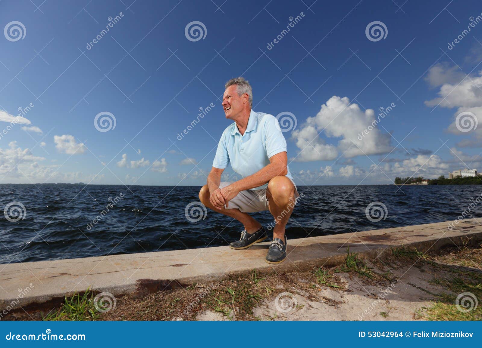 Man perched on the seawall stock photo. Image of saturated - 53042964