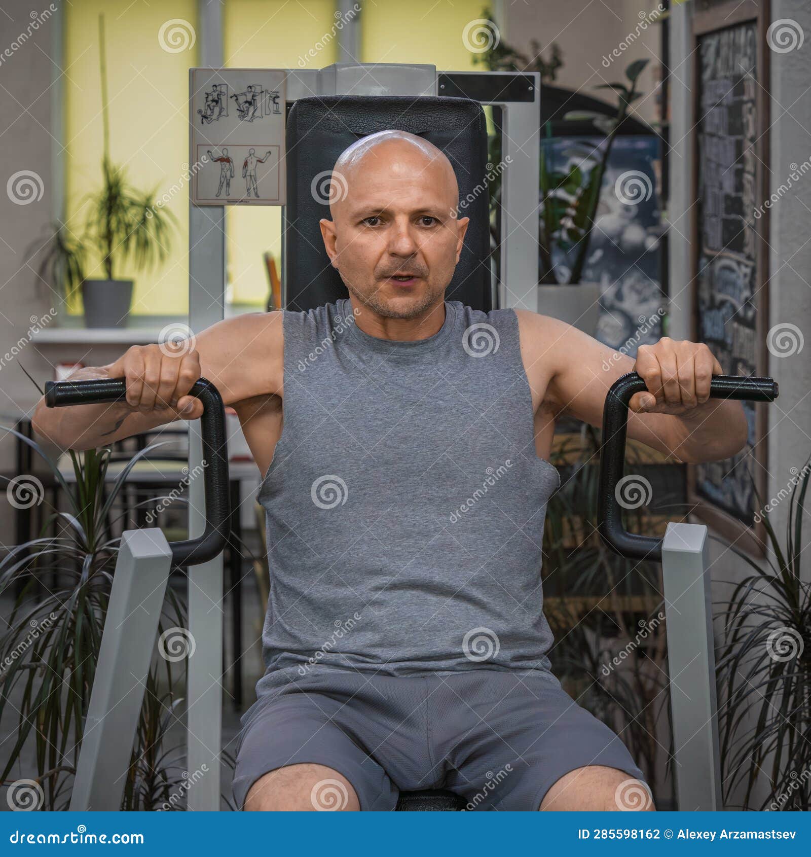 Man Performs an Exercise on a Simulator for Pumping Chest Muscles Stock ...