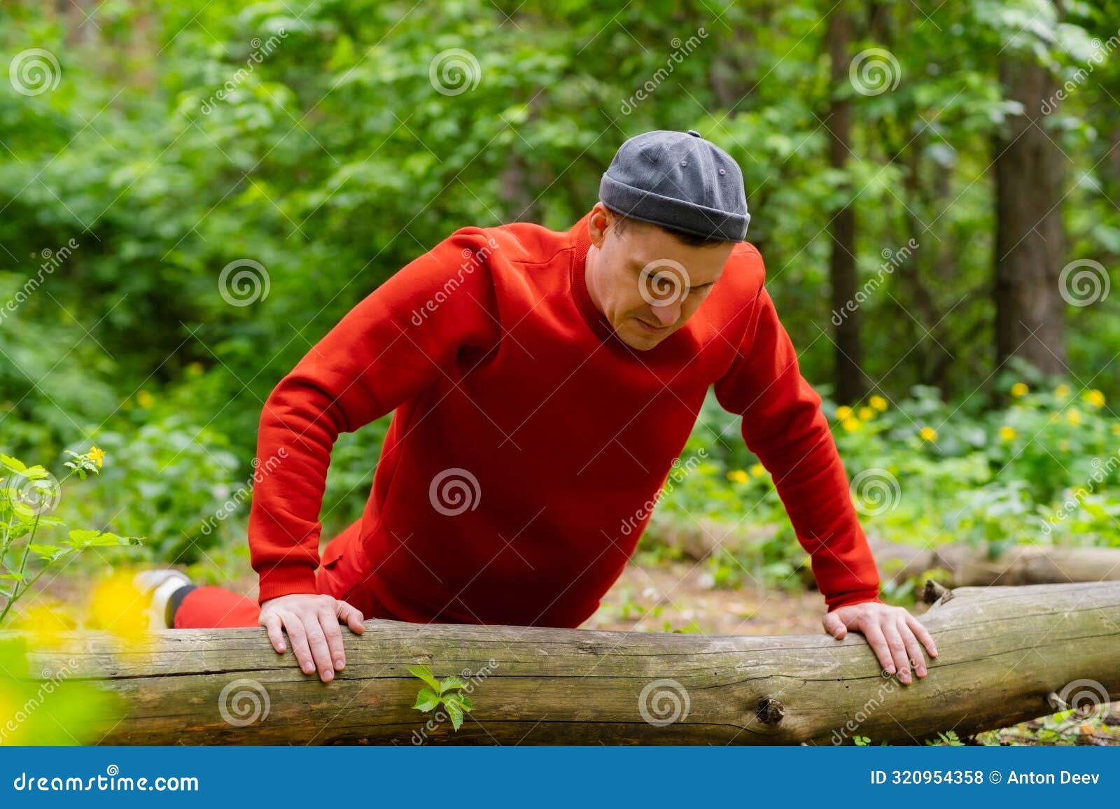 A Man Performs Push-ups Using the Log As Support. the Backdrop is a ...
