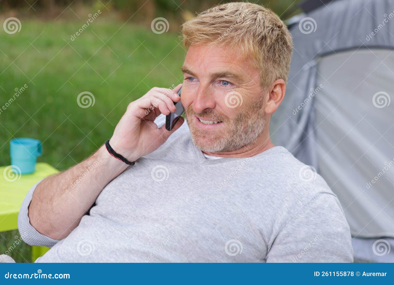 Man on Phone Sitting Near Tent Stock Photo - Image of cellphone ...