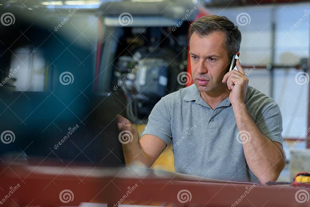 Man on phone in workshop stock image. Image of anonymous - 315449639
