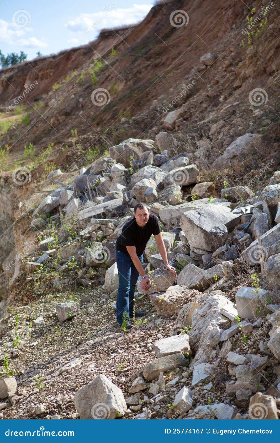 The man picks up a stone stock image. Image of material - 25774167