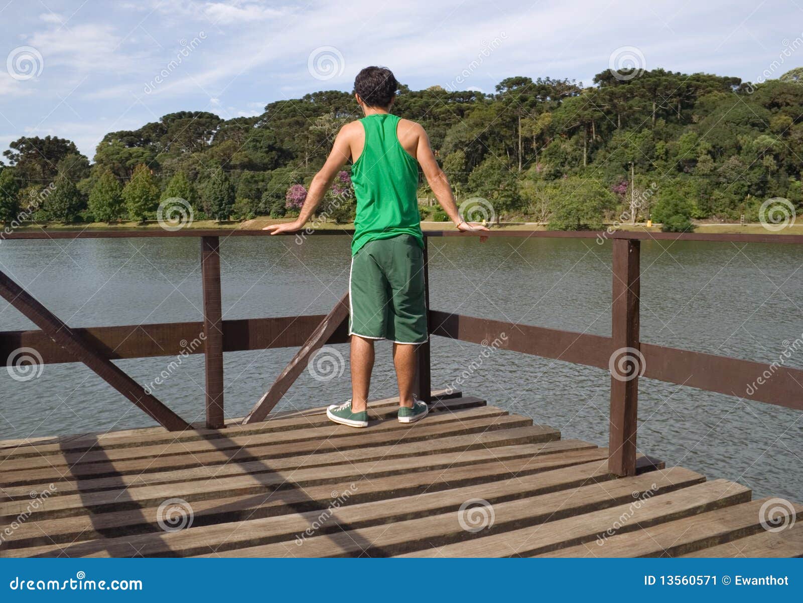 Man on pier by scenic lake stock image. Image of cloudscape - 13560571