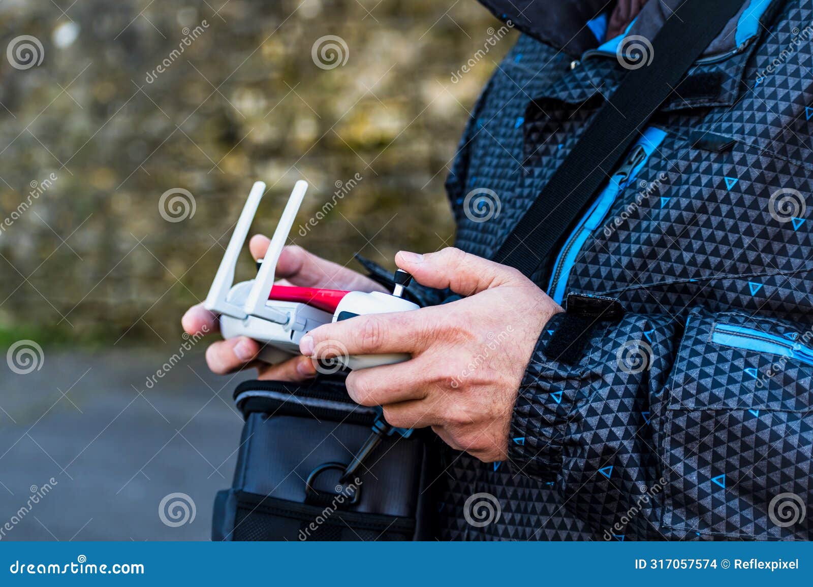 Man Piloting a Drone Using a Controller Equipped with a Joystick and a ...