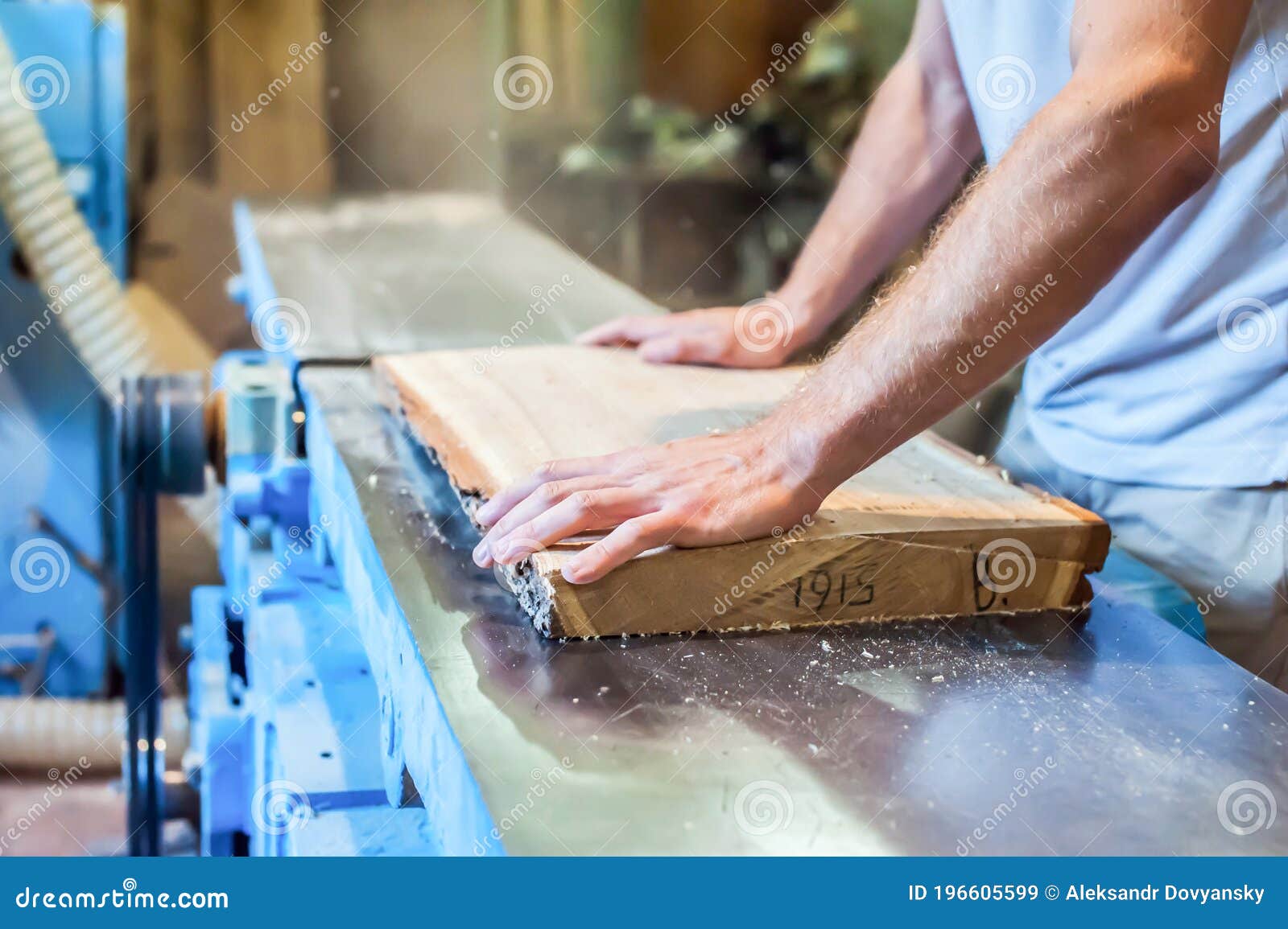 A Man Planes a Board on a Large Industrial Jointer in a Carpentry ...