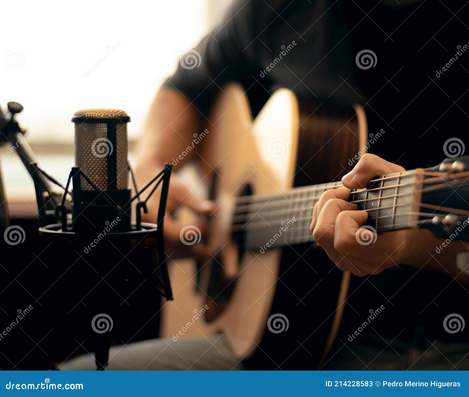 Man Playing Acoustic Guitar and Recording with a Microphone in a Room ...