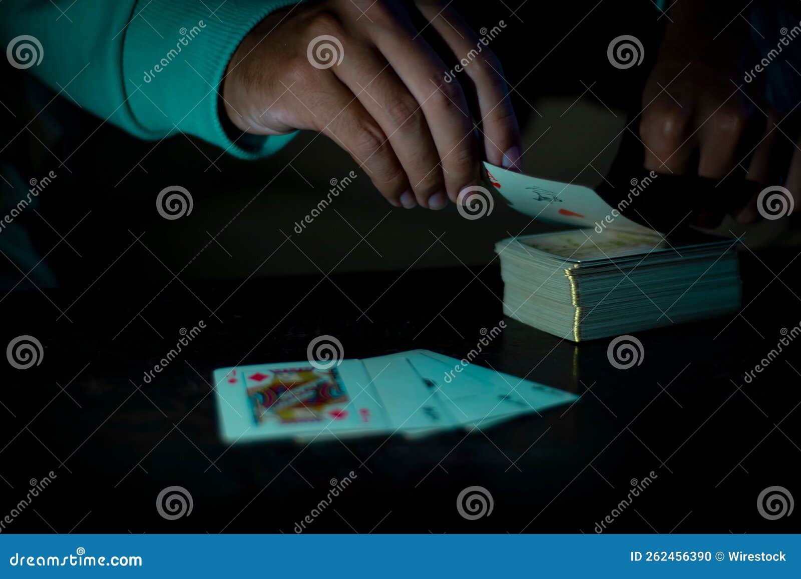 Man Playing with Cards on a Table in a Dark Background Stock ...