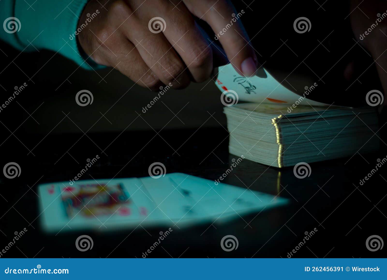 Man Playing with Cards on a Table in a Dark Background Stock ...