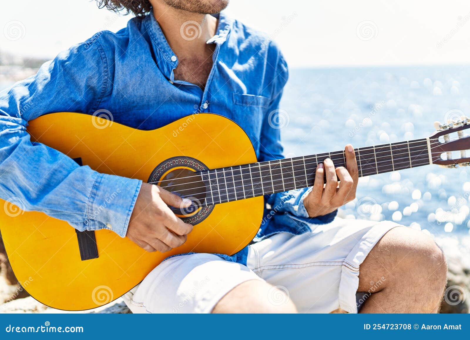Man Playing Classical Guitar Sitting on Rock at the Beach Stock Photo ...