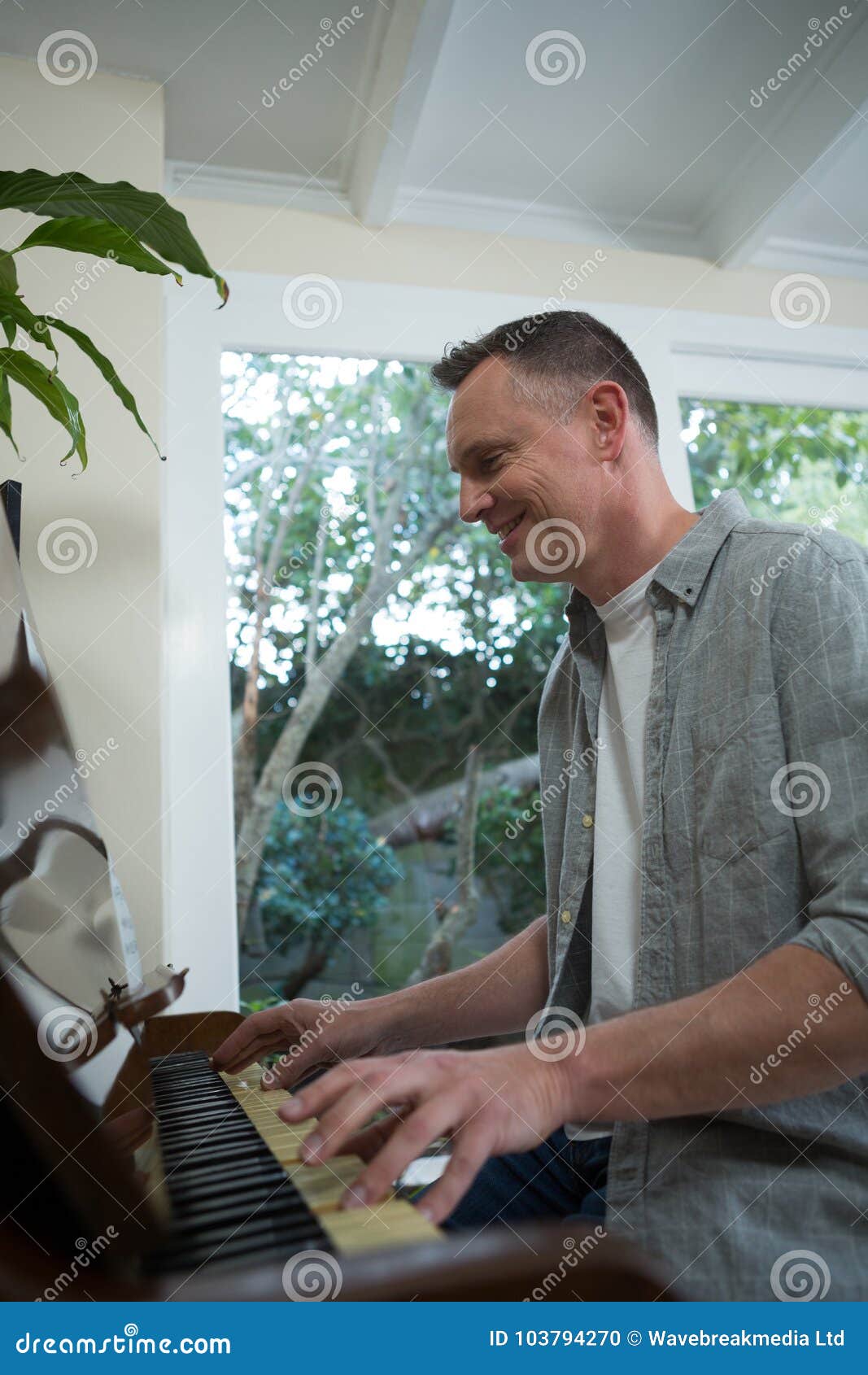 Man playing piano at home stock photo. Image of apartment - 103794270