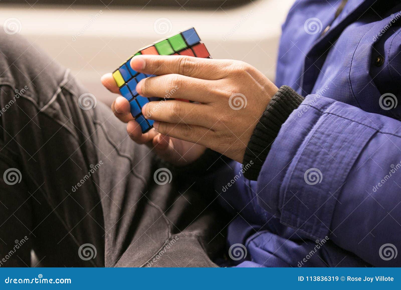 Man playing the Rubix cube editorial stock image. Image of block ...