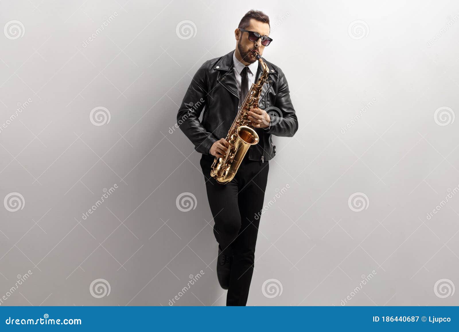 Man Playing a Saxophone and Leaning on a Wall Stock Image - Image of ...