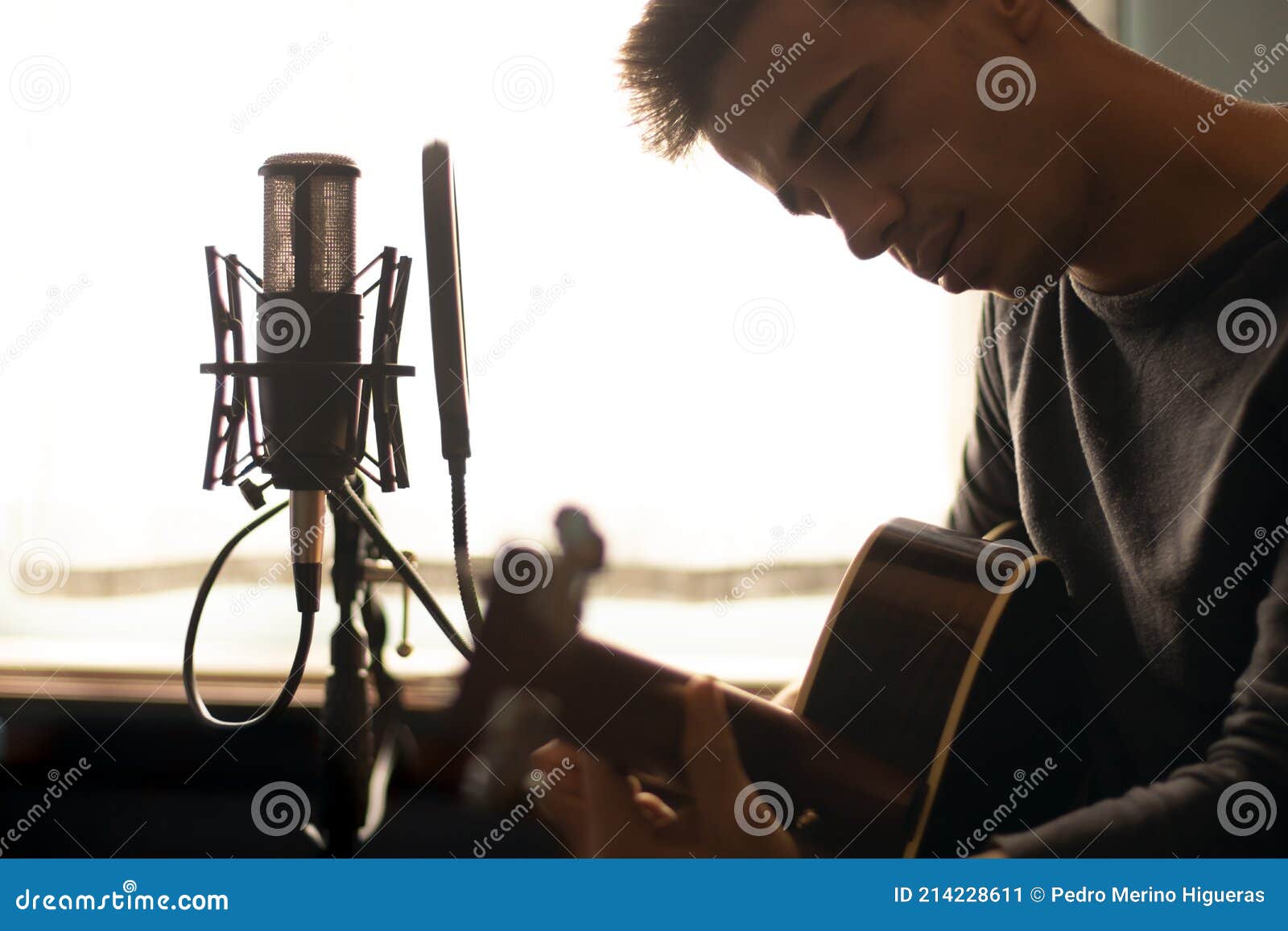 Man Playing Spanish Guitar and Singing while Recording it with a ...
