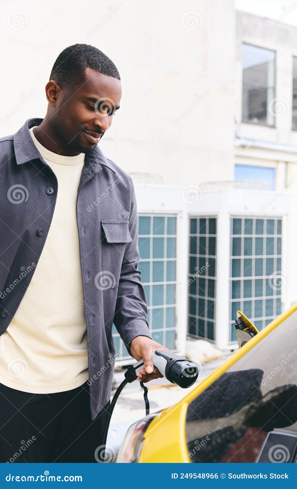 Man Plugging in Electric Car Outside Office in Car Park Charging Stock ...