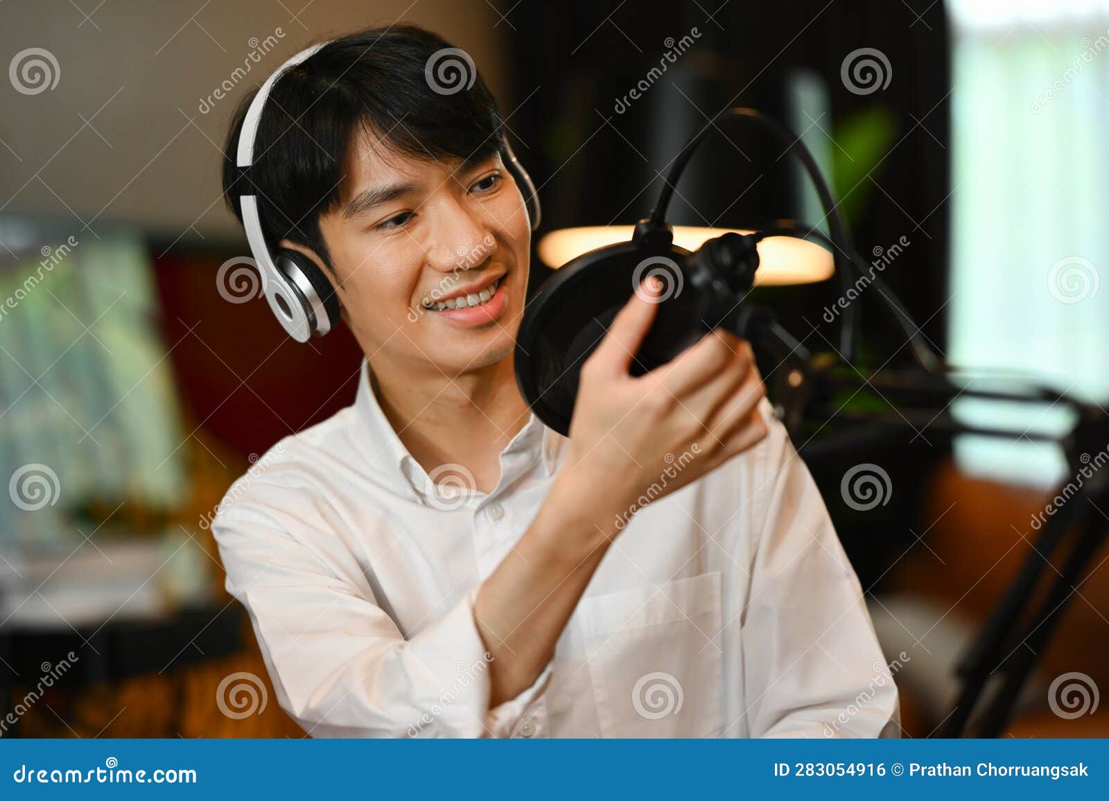 Man Podcaster Wearing Headphone Talking into a Microphone while Making ...