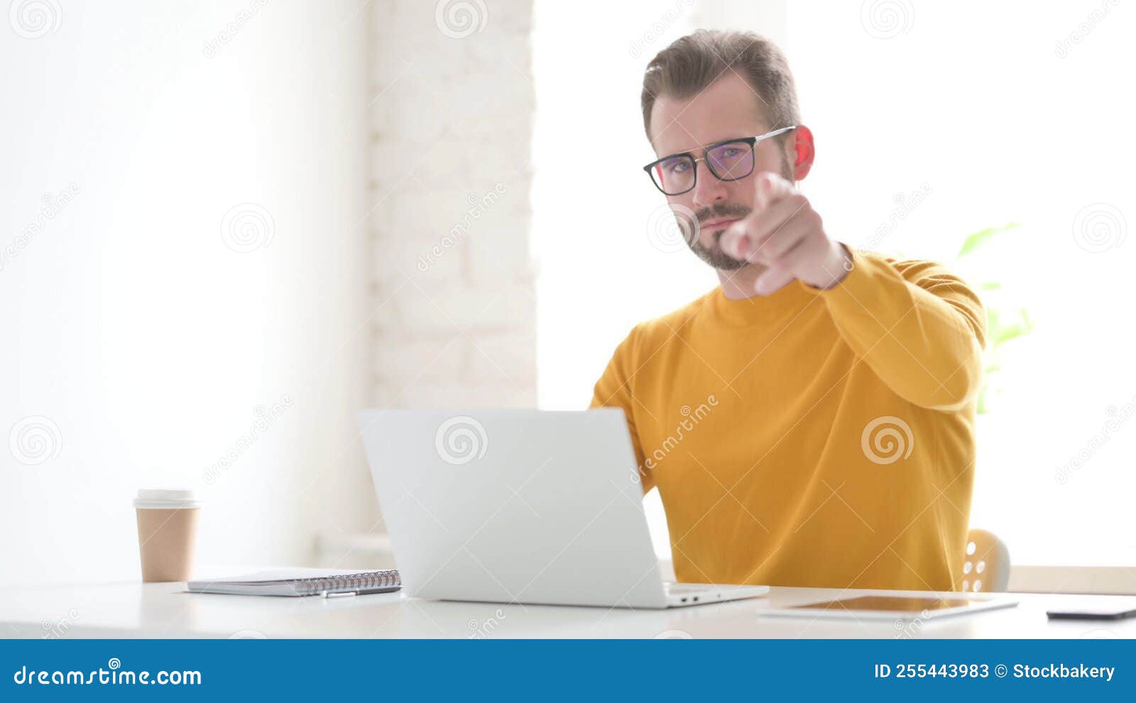 Man Pointing at Camera while Using Laptop in Office Stock Image - Image ...
