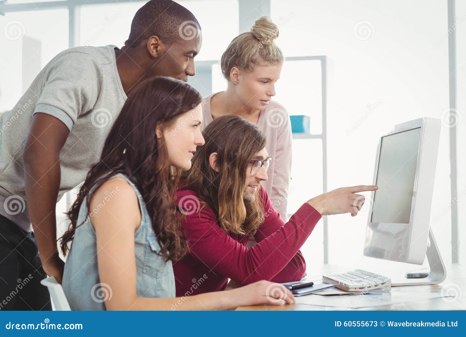 Man Pointing at Computer while Working with Coworkers in Creative ...