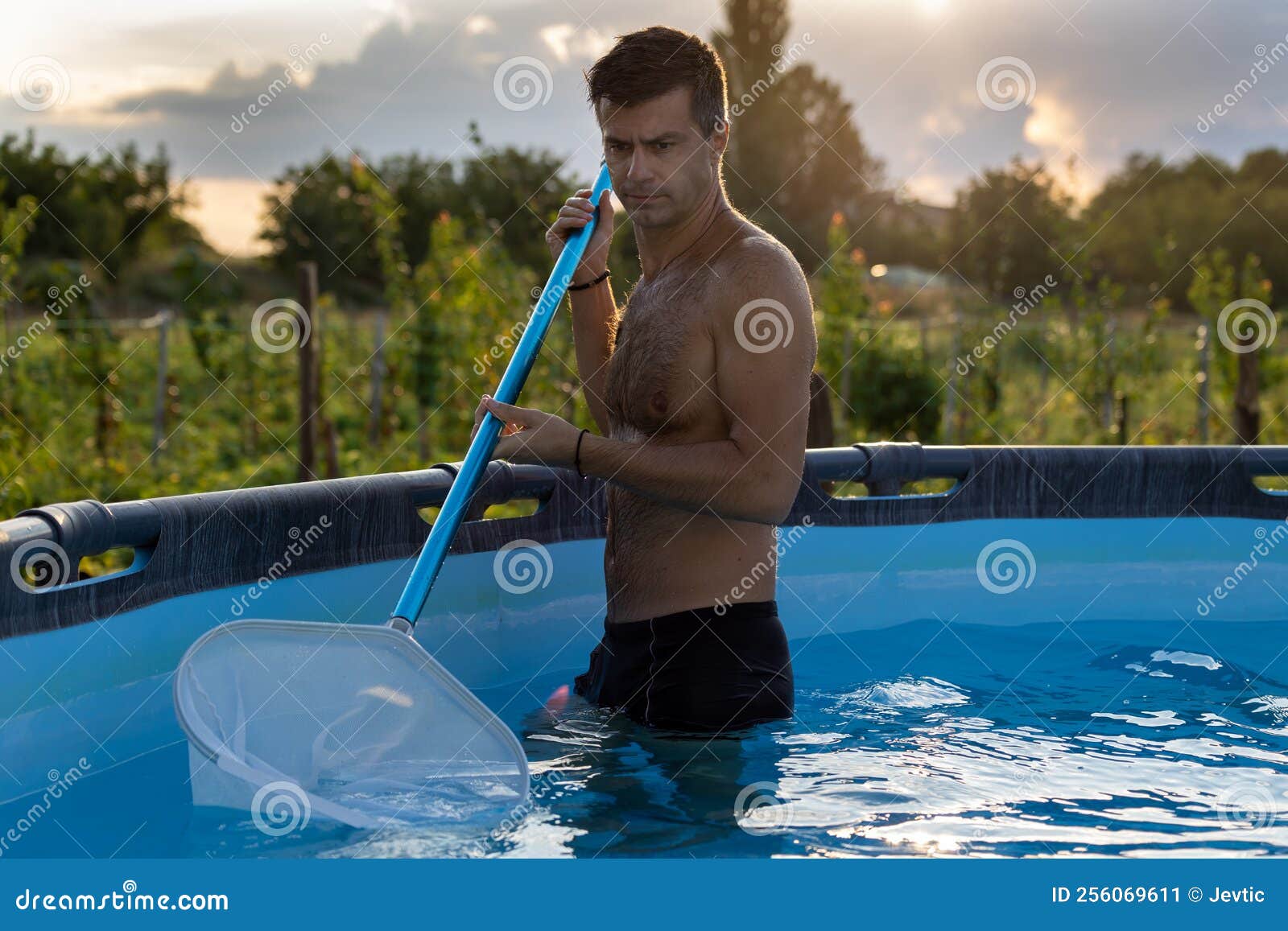 Man cleaning pool with net stock image. Image of cleaning - 256069611