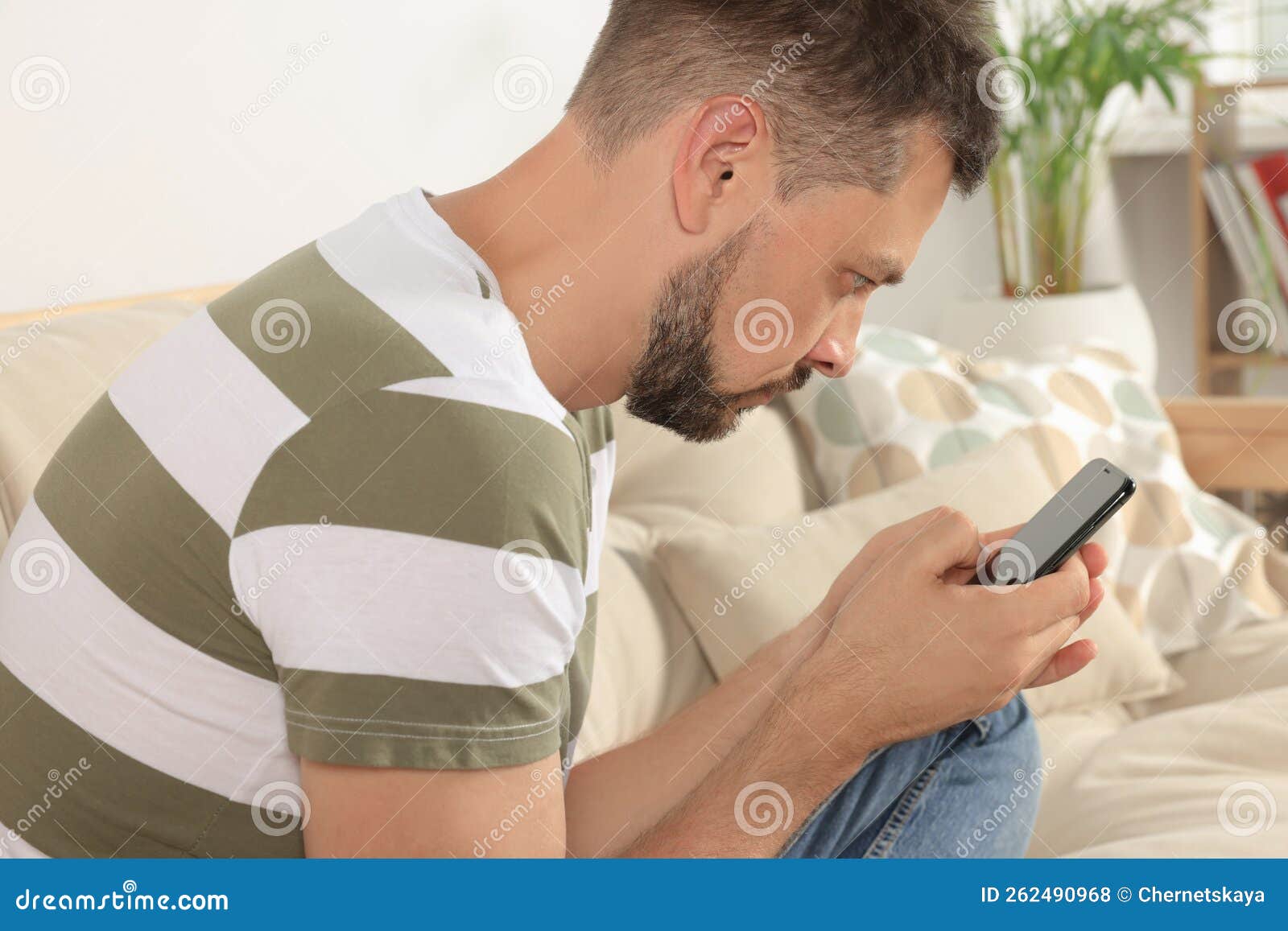 Man with Poor Posture Using Smartphone on Sofa at Home Stock Photo ...