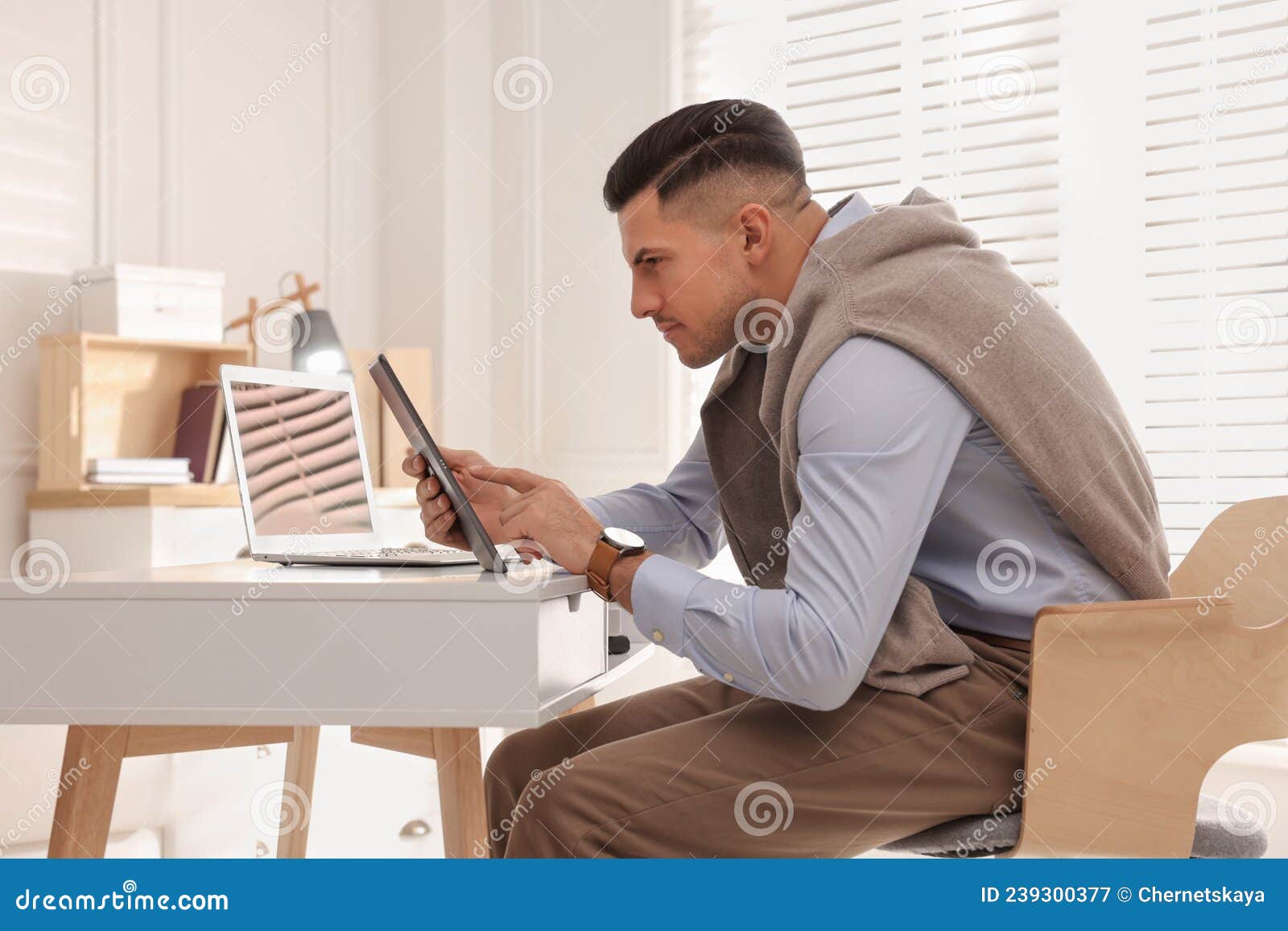 Man with Poor Posture Using Tablet at Table Indoors Stock Image - Image ...