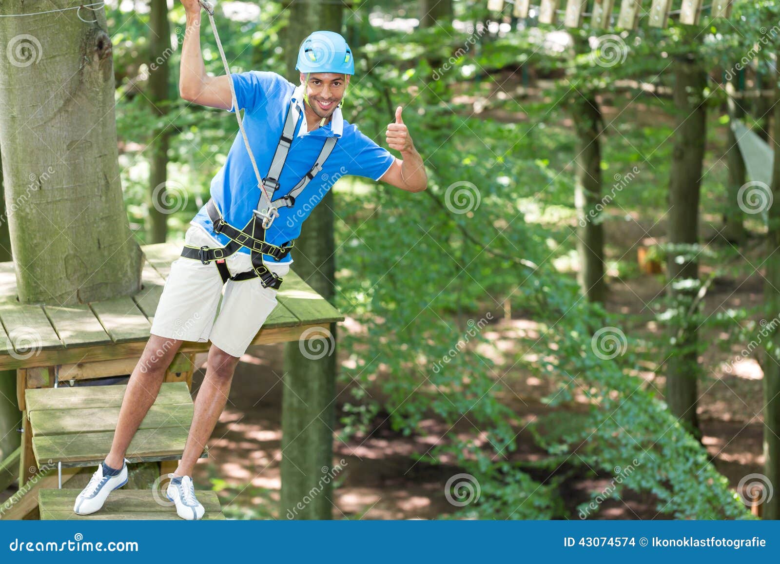 Man Poses on Platform at High Rop Course Stock Photo - Image of person ...