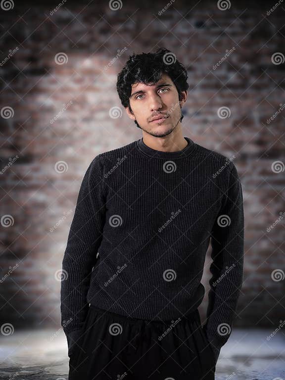 A Man Posing Heroically Against a Textured Brick Wall Stock Photo ...