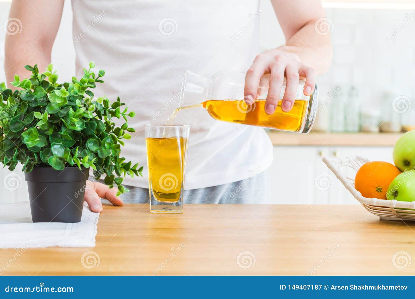 Man Pouring Apple Juice from Jug into Glass in the Kitchen Stock Image ...